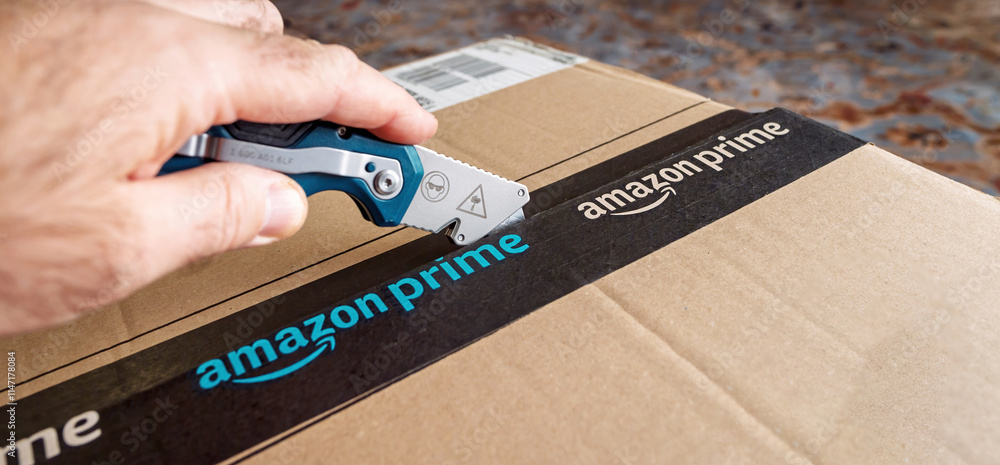 Paris, France - Dec 1, 2024: Close-up of a hand cutting Amazon Prime ...