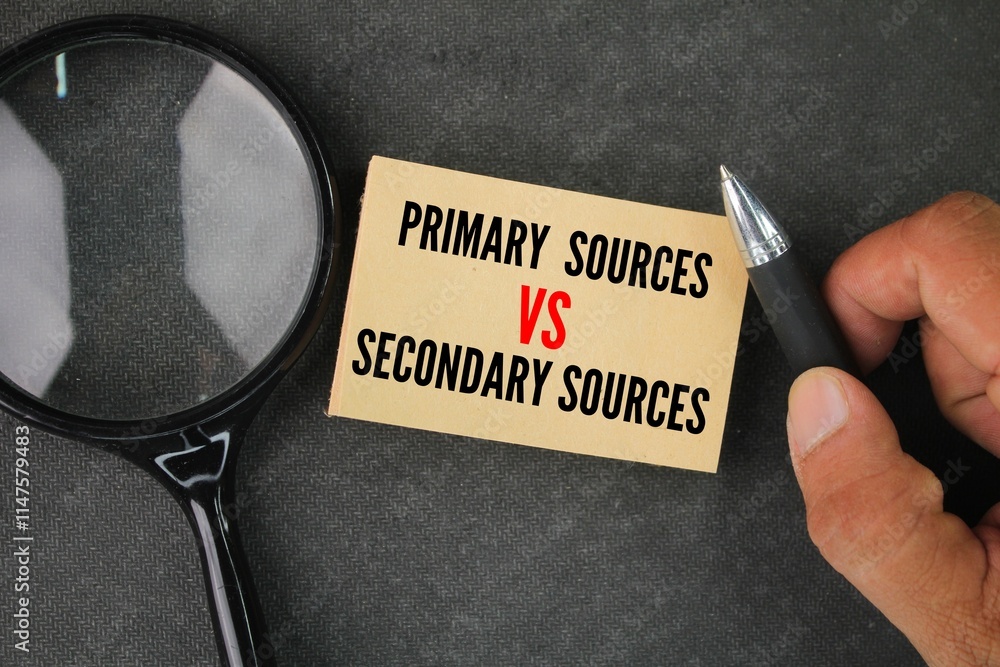 magnifying glass, pen and paper with the words Primary Sources vs ...