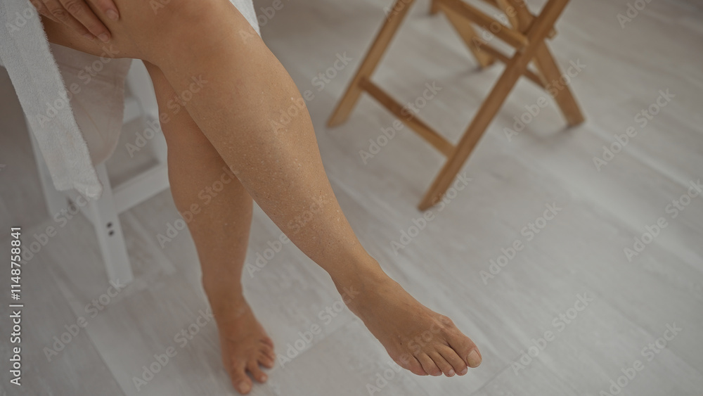 Woman relaxing indoors at a spa center with legs crossed in a wellness ...