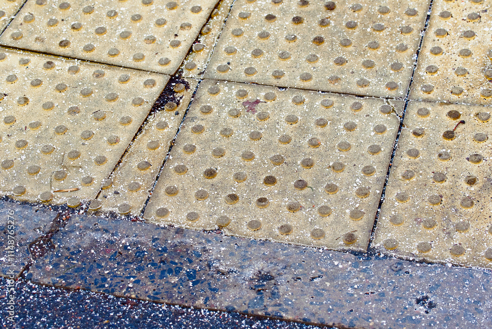 Tactile paving tiles treated with salt grit mixture for winter safety ...