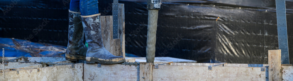 Construction worker walking on wood cement form panels for foundation ...
