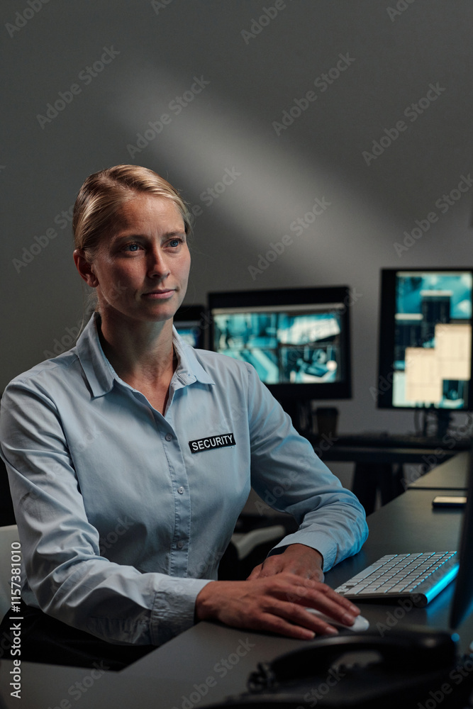 Young blond female security guard or officer of observation room ...