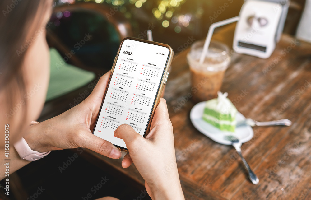 Businesswoman using smartphone with monthly calendar to plan 2025 ...
