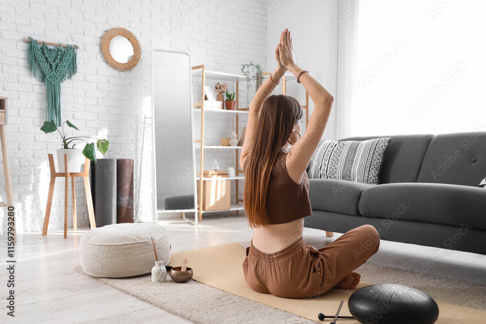 Young woman meditating at home, back view Stock Photo | Adobe Stock