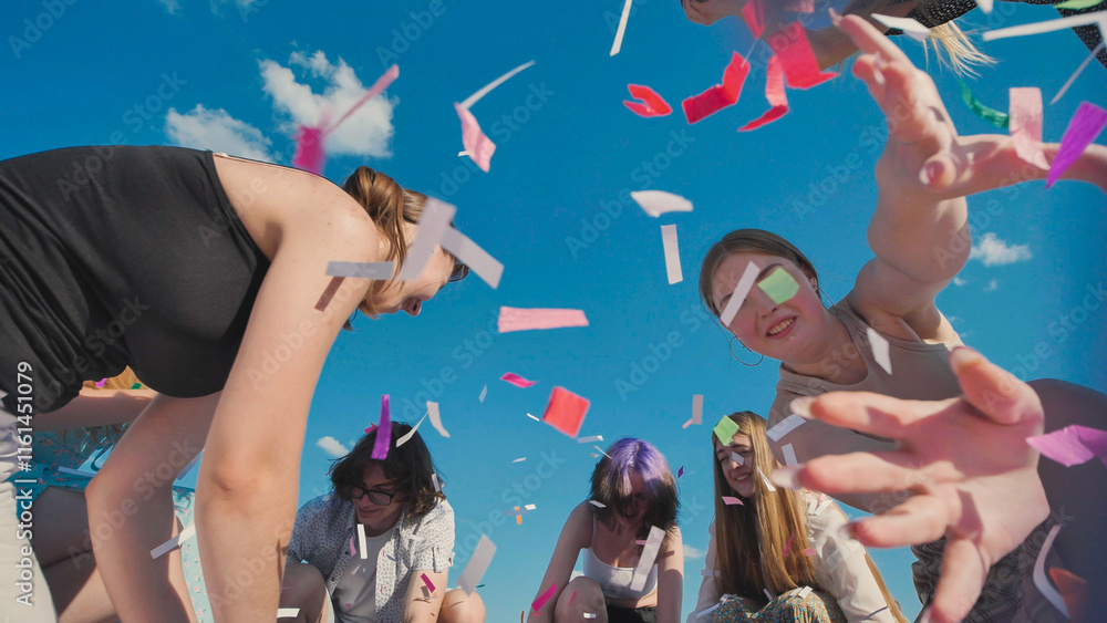 Group of high school students throwing colorful confetti in the air ...
