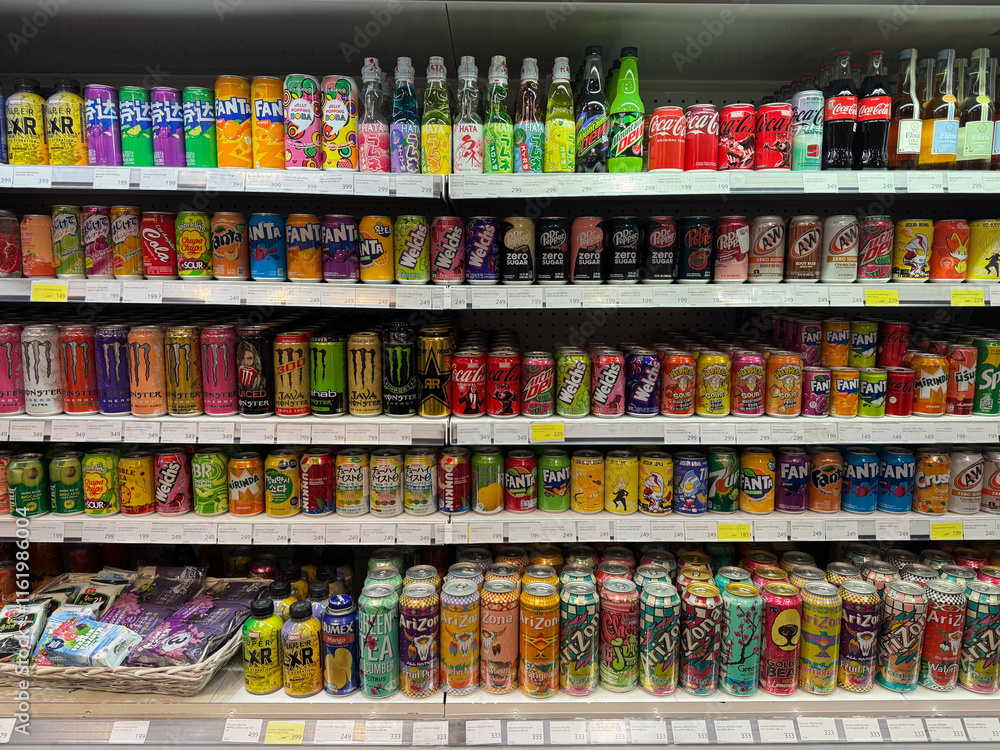 Assorted soft drinks fills shelves of grocery store. Colorful cans with ...