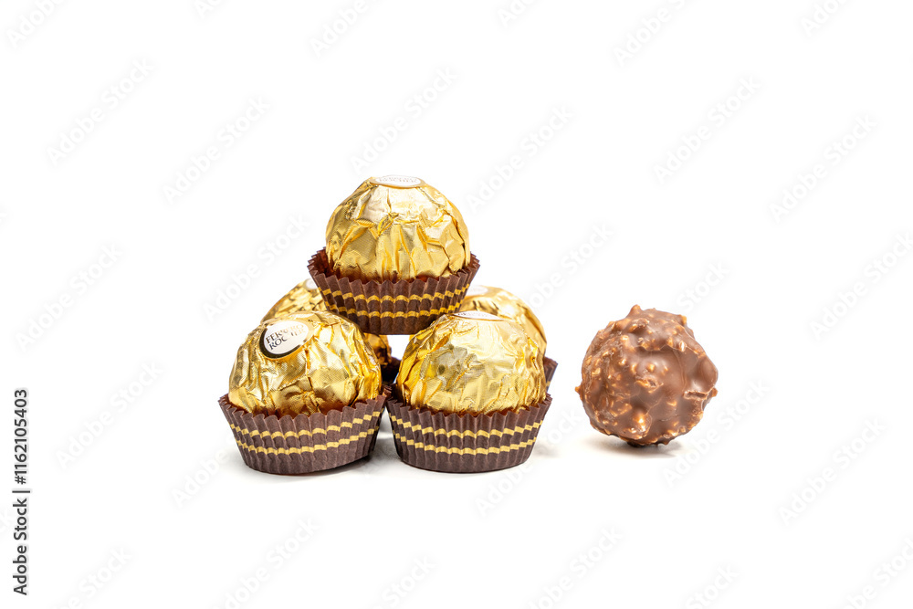 A stack of Ferrero Rocher chocolates with one chocolate on top. Golden ...