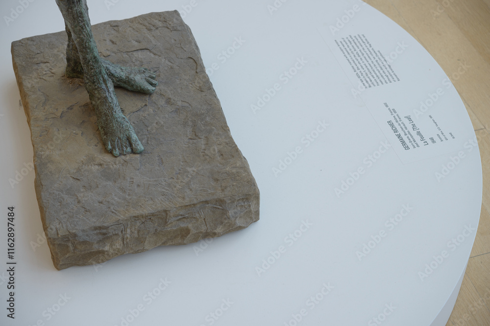 modern bronze statue on stone base, didactic label, and round podium at ...