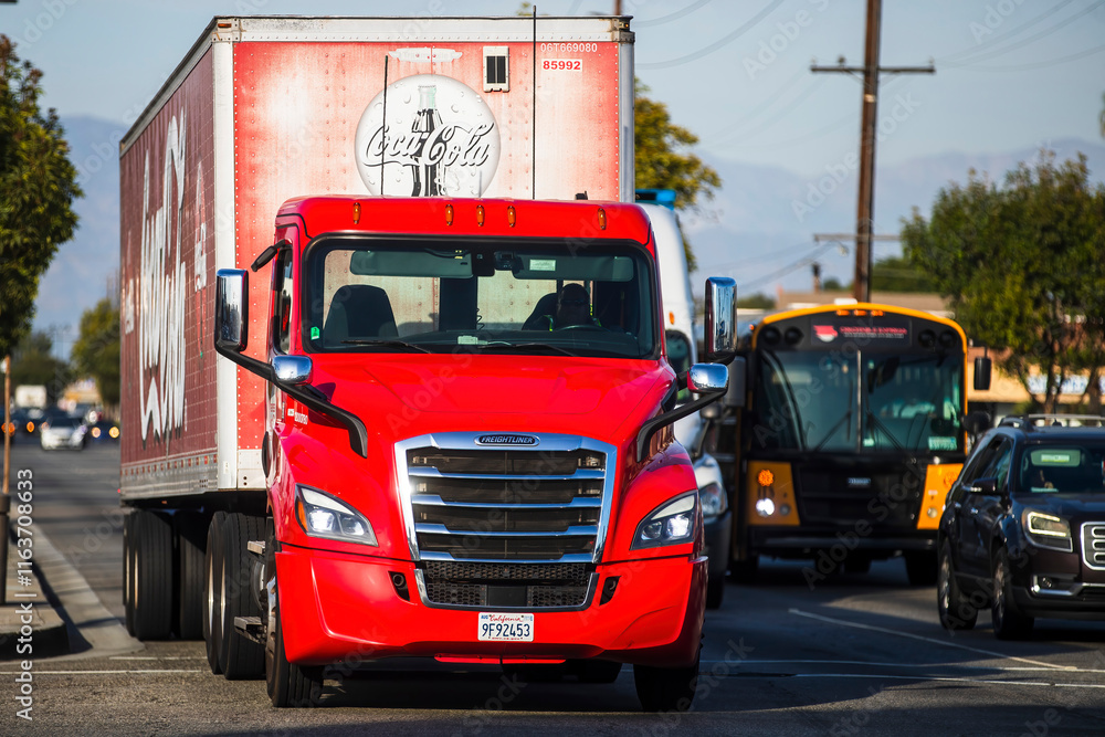 Red Freightliner truck, pulling a Coca-Cola trailer, turns a corner at ...