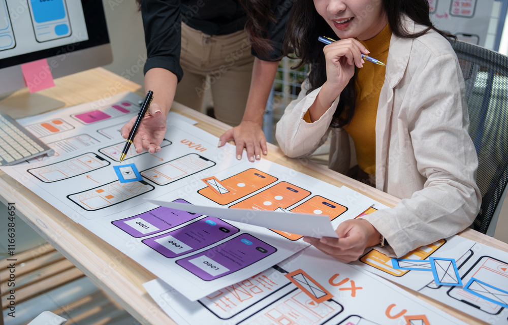 Two Female Web Designers Collaborating On Ux Design For A Mobile Application During A Meeting