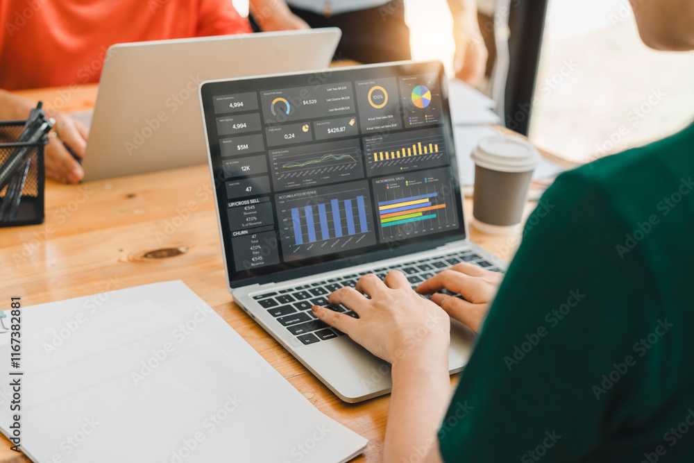 person working on laptop displaying data analytics dashboards with charts and graphs, sitting at ...