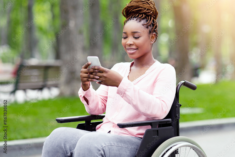 Happy handicapped black woman in wheelchair using smartphone, checking ...