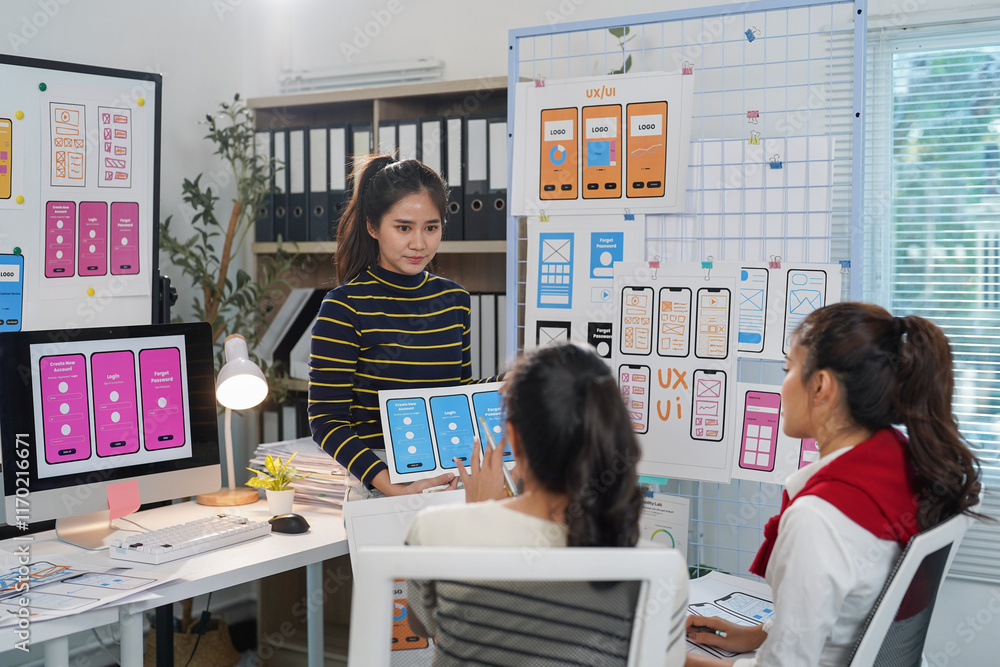 Asian female web designers working together discussing user interface ...