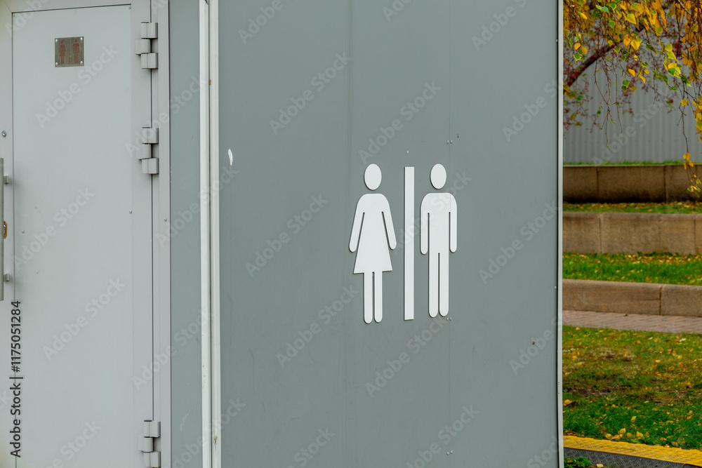 Sign indicating restroom facilities for men and women in a public park ...