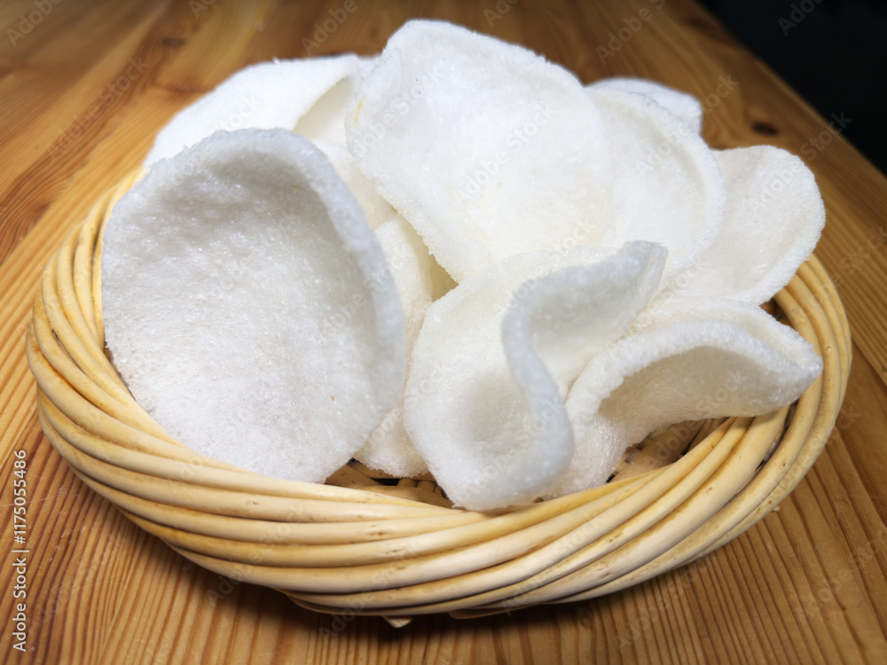 Closeup of crisp white deep fried prawn crackers, piled up in a wicker ...