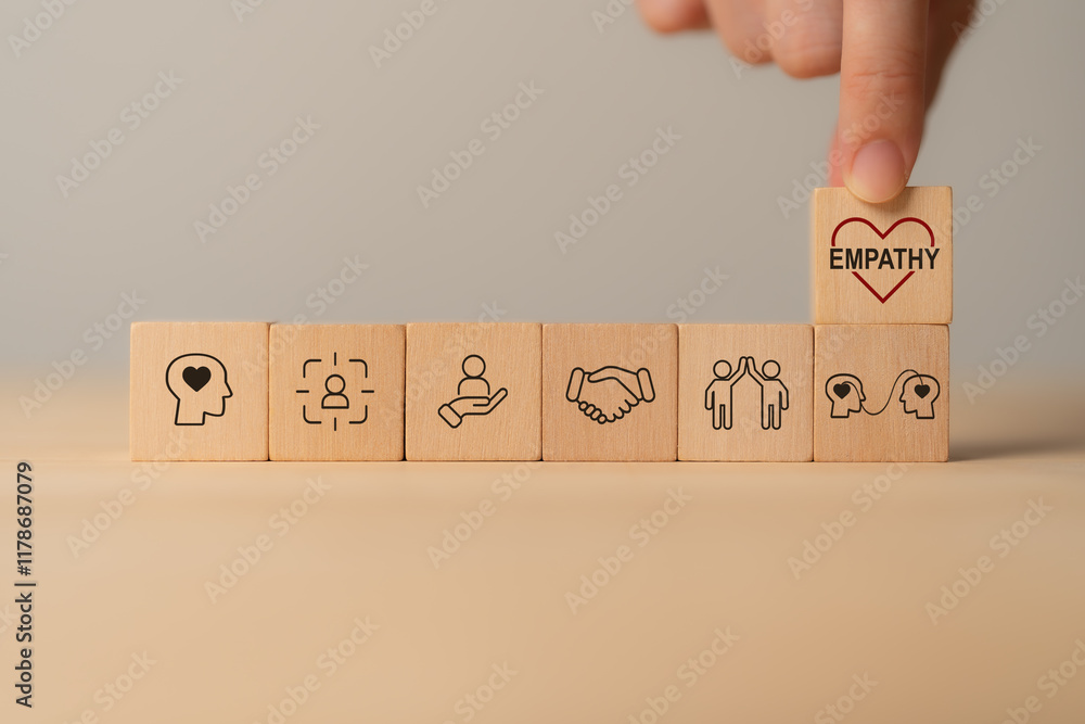 Empathy concept. Wooden blocks with empathy icons on minimal background and copy space. The ...