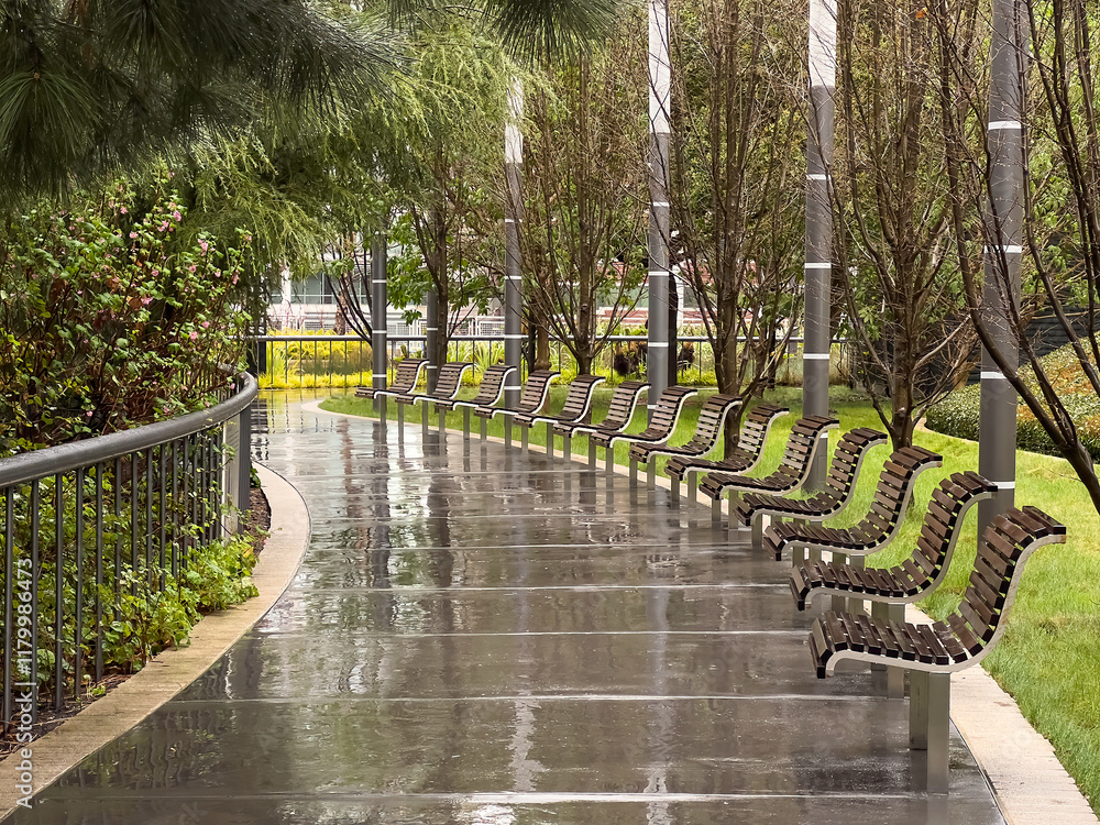 Row of wet immovable seats along a curved reflective walkway in a large ...