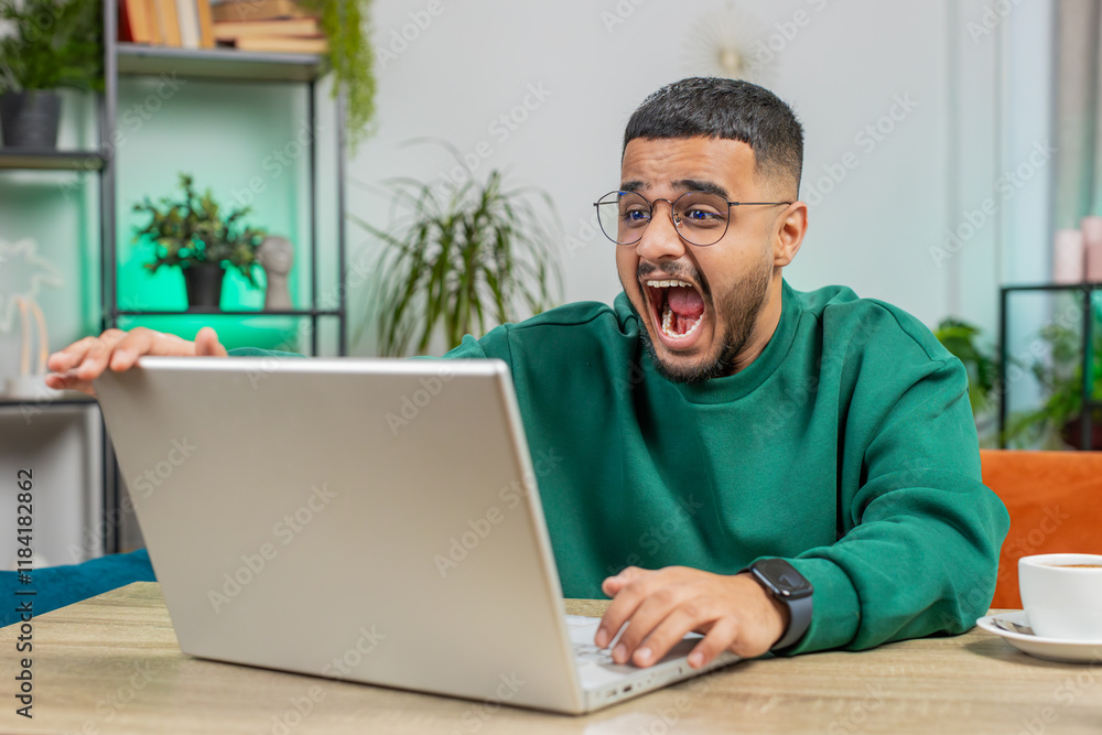 Displeased Indian man use laptop notebook browsing working screaming ...