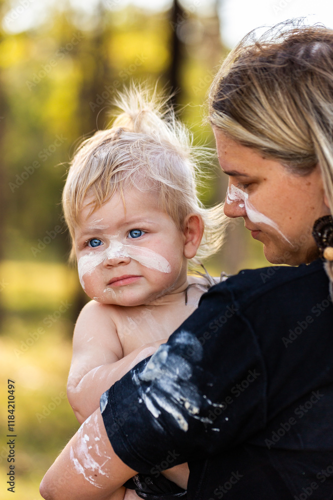 Aboriginal mum cuddling baby boy in Australian bushland painted with ...