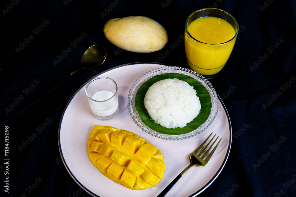 Fresh mango with sticky rice and juice on a black background. Dessert ...