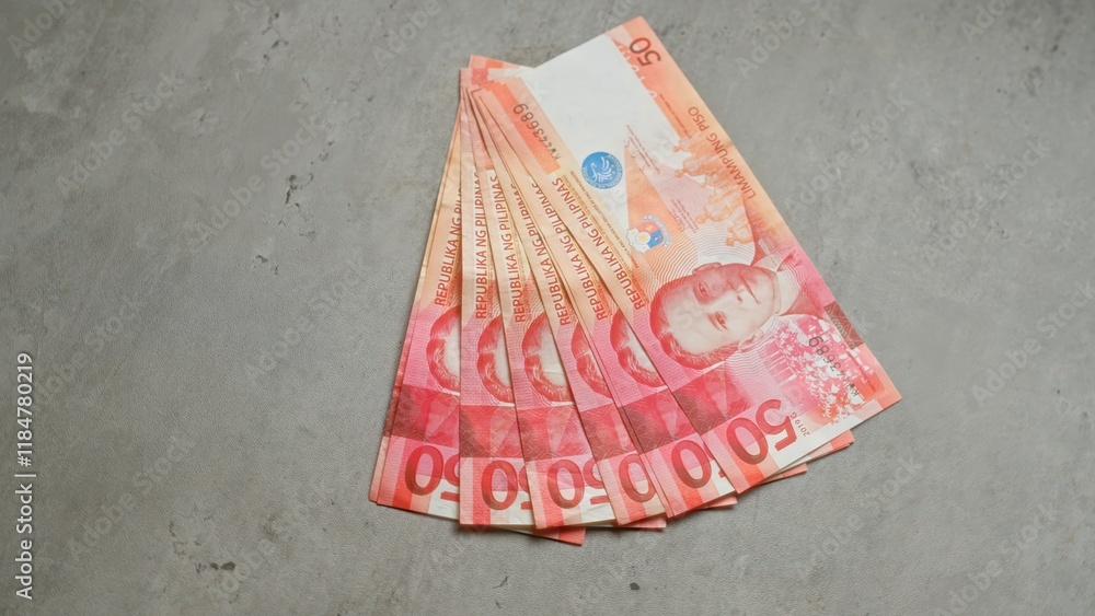 Filipino pesos laid out on a concrete surface, showcasing philippine ...