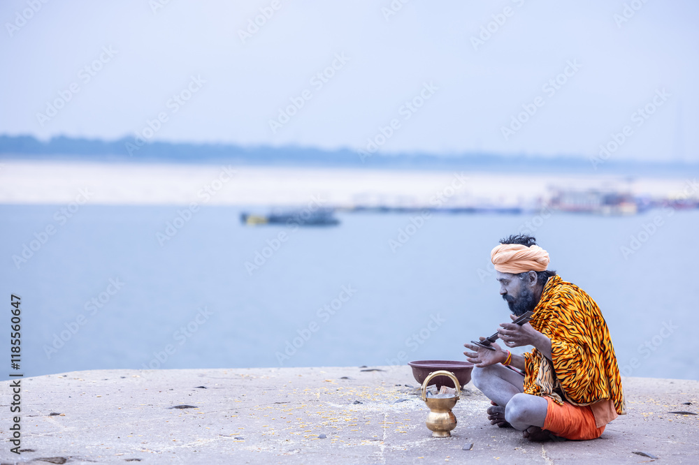 Portrait of an holy naga sadhu baba sitting on ghats near river ganga ...