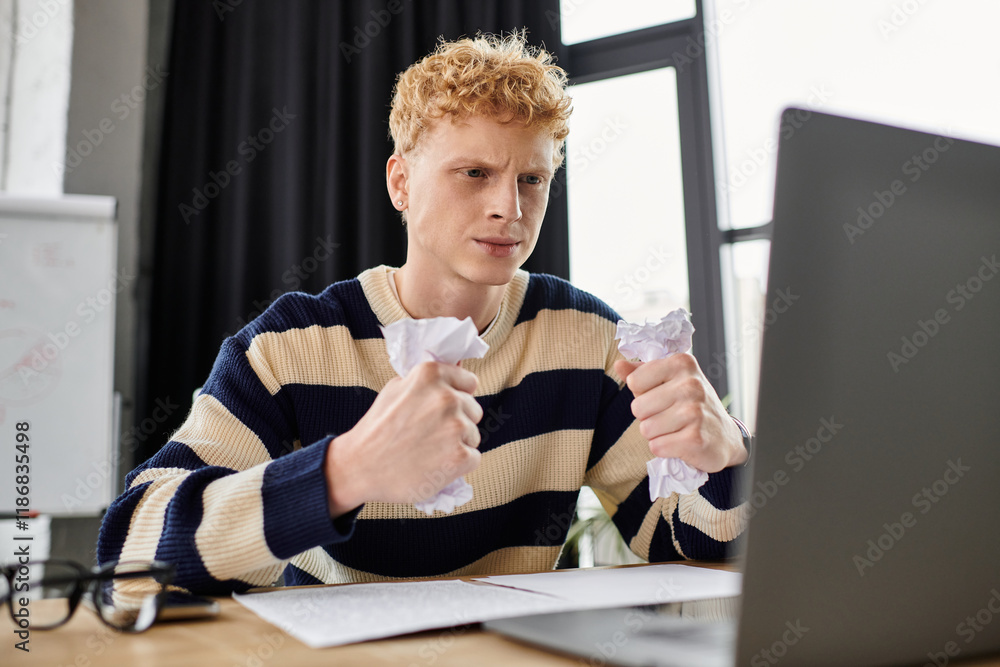Frustrated young man in a striped sweater confronts work challenges at ...