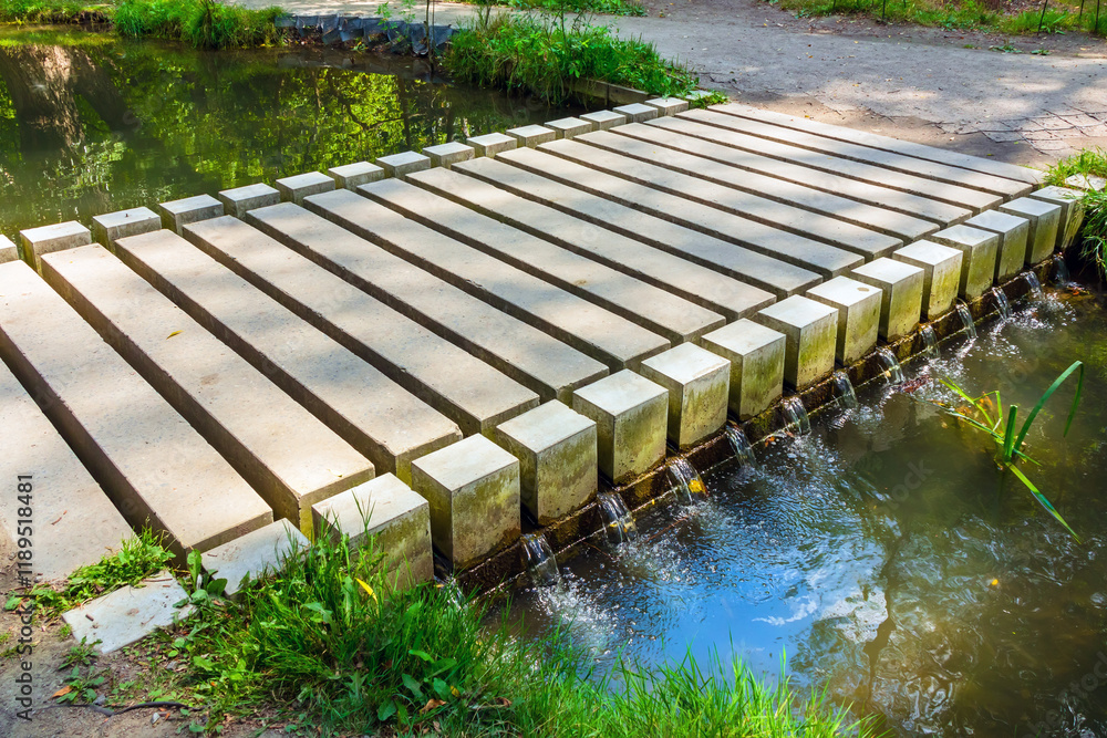 Modern concrete pedestrian bridge over a stream. Footbridge at water ...