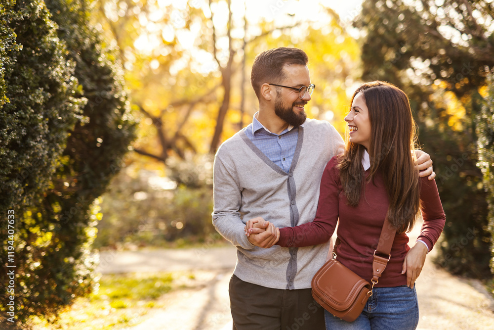 Young happy romantic couple taking a walk in public park and hugging on ...