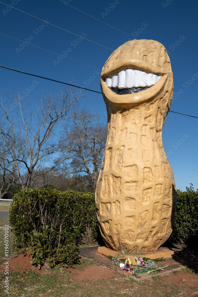 The "Smiling Peanut" with flowers at its base, a whimsical sculpture in ...