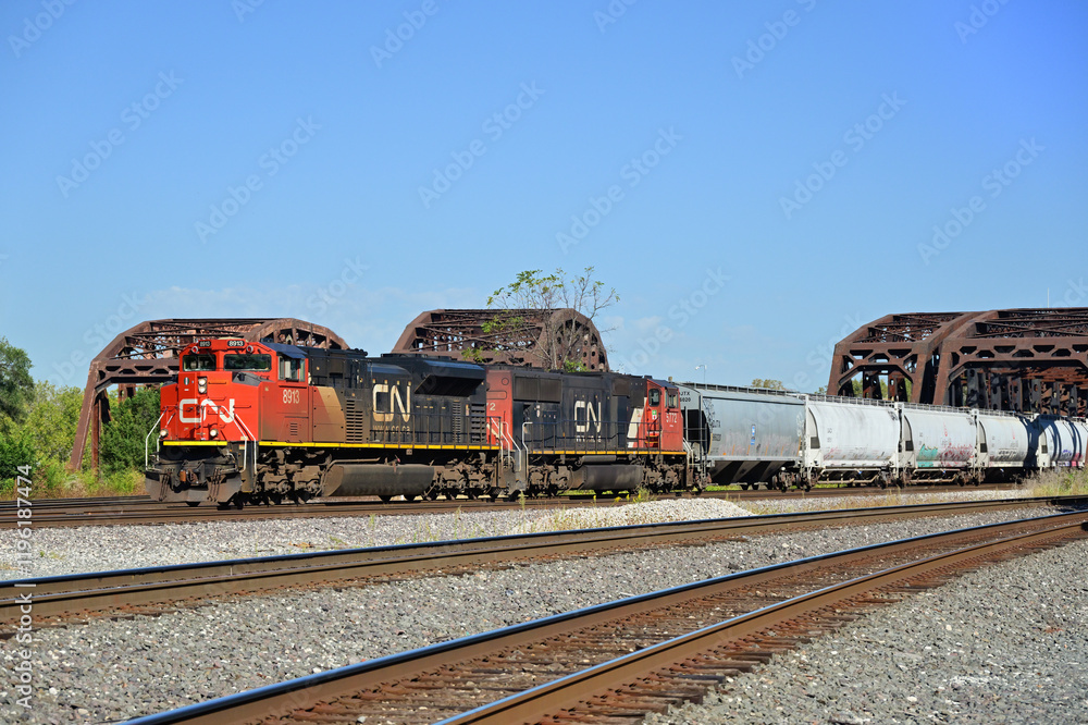 Canadian National Railway locomotives lead a grain train across one of ...