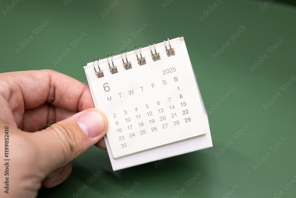 Hand holding mini calendar for 2025 JUNE background. Calendar concept ...