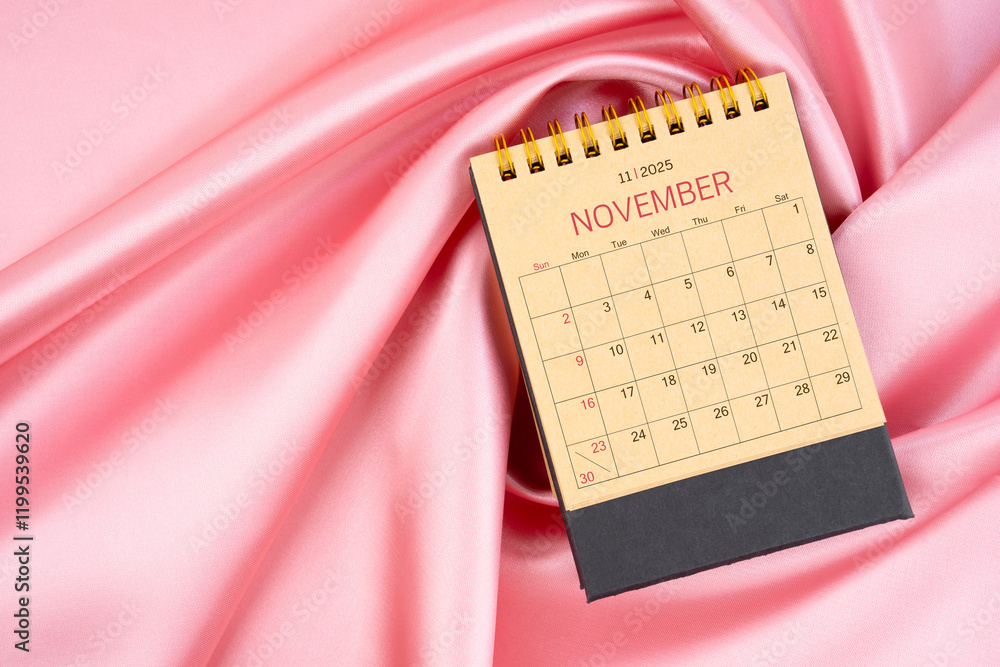 November 2025 craft brown paper desk calendar on pink silk textile ...