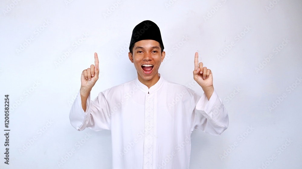 handsome asian muslim youth pose pointing up with isolated white ...