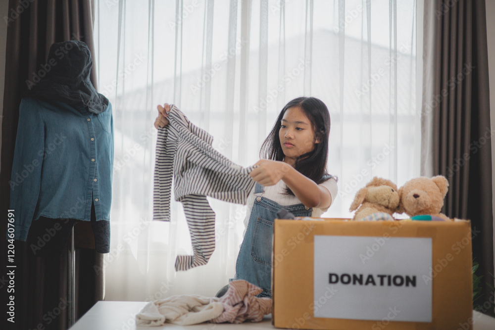 Recycling, Donation for poor, Asian girls packing objects at home, putting on stuff into donate ...