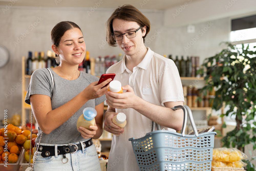 Couple young man and young woman scanning qr code for sauces at grocery ...