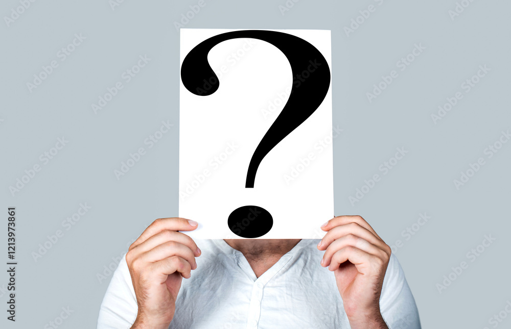 Zdjęcie bez tantiem: Man holding question mark sign on light background ...