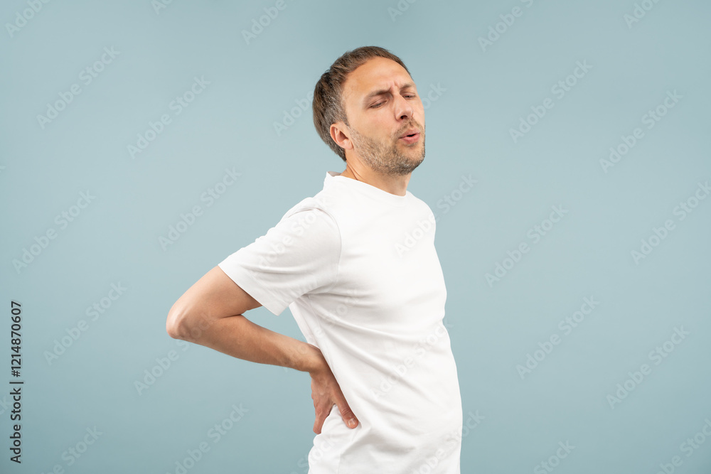 Unwell man holding lower back in pain with discomfort feels symptoms of ...