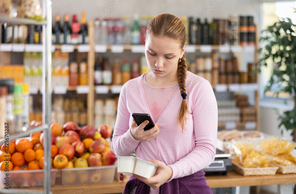 Checking expiration date of yogurt - female shopper scans QR code on ...