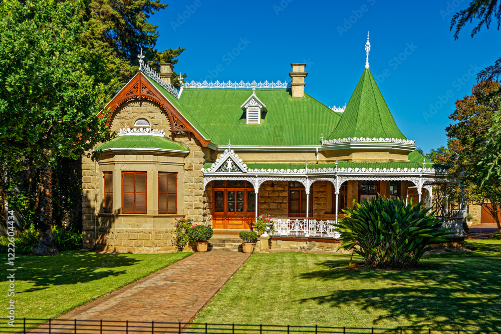 Gabled sandstone Victorian style house with a green roof and decorative ...