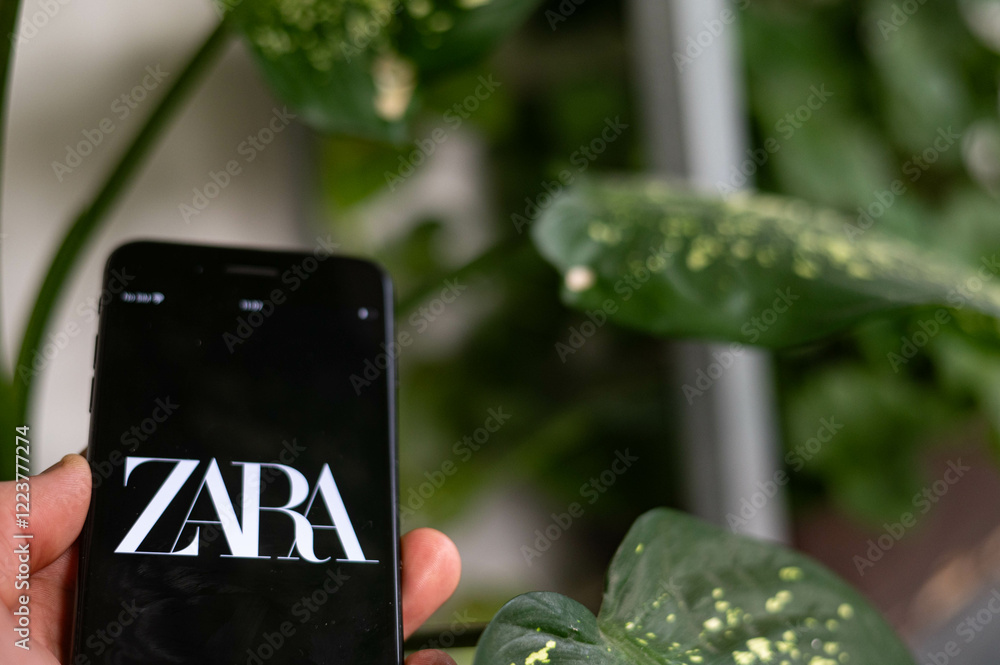 Zara logo on the screen of mobile phone. Fast fashion industry Stock ...