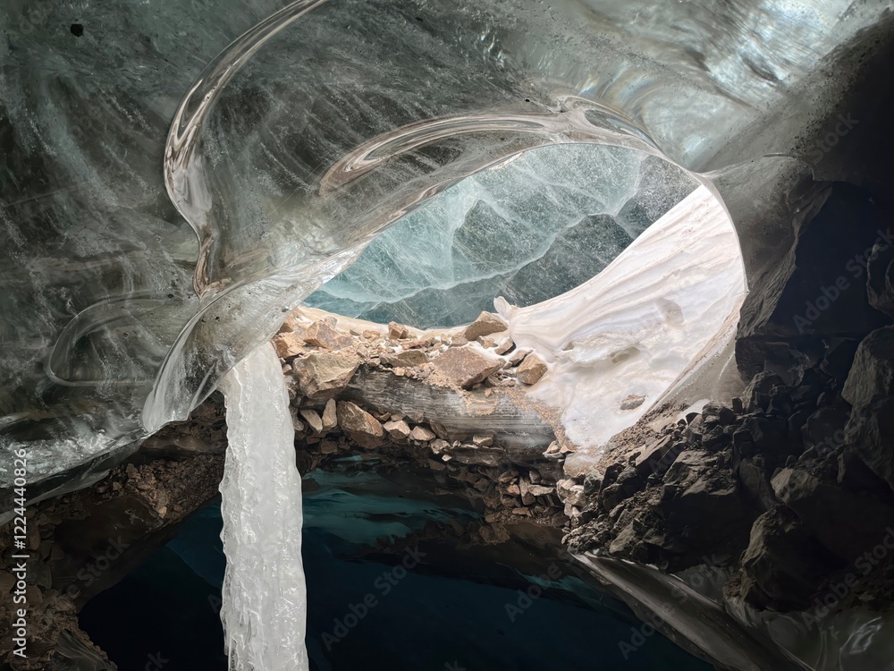 icy glacier cave with frozen waterfall and rugged rocky terrain ...