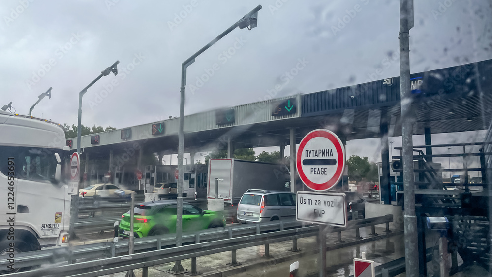 A rainy day at a congested toll booth symbolizes traffic issues, with ...
