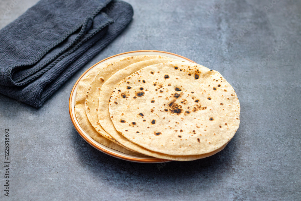 Roti is a soft, round flatbread made from whole wheat flour, commonly ...