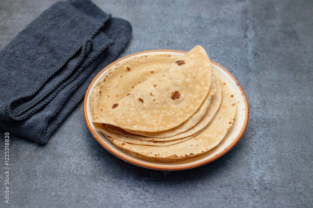 Roti is a soft, round flatbread made from whole wheat flour, commonly ...