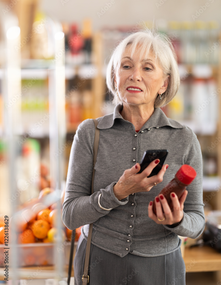 Female shopper scanning QR code on bottle ketchup label in grocery ...