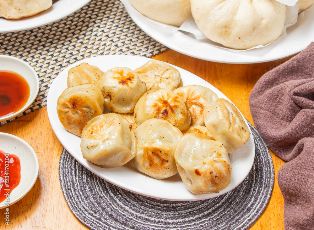 Shanghai Fried Buns or Momo with Dipping Sauce served in plate isolated ...