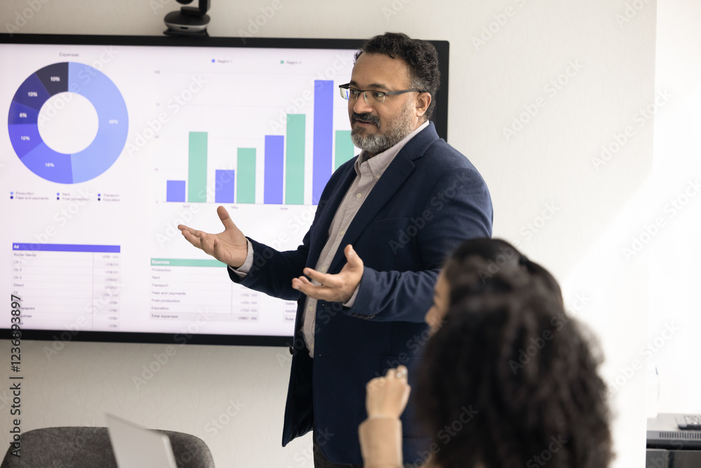 Mature Indian company CEO presenting sales growth analytics to group of ...
