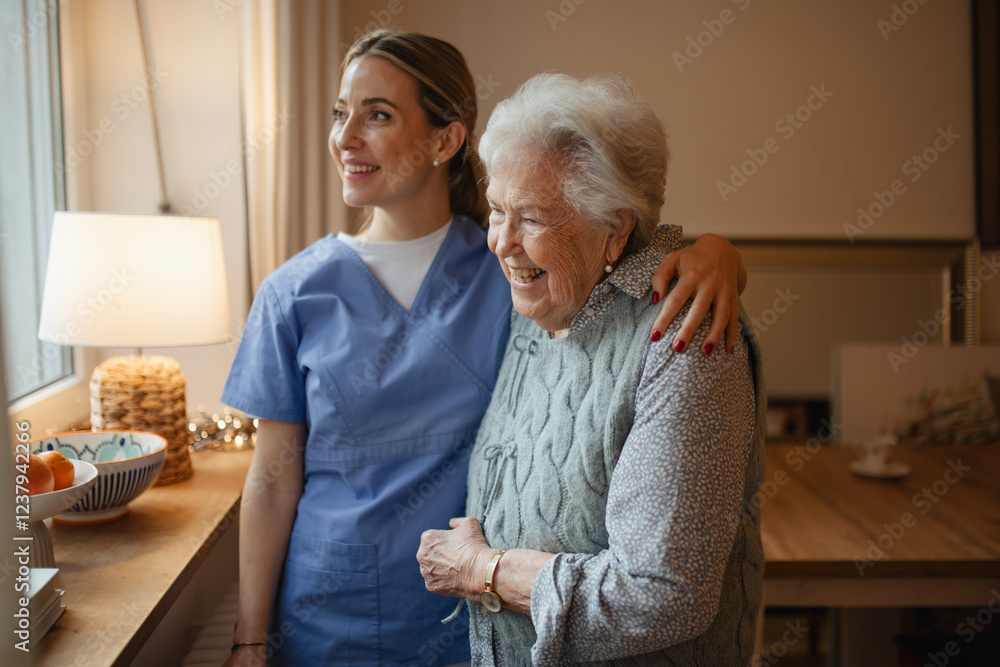 Caring healthcare worker visiting a senior patient at home, hugging her ...