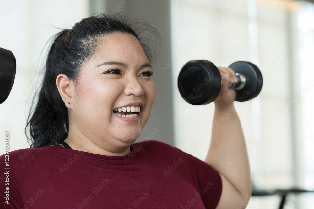 Happy smiling Asian young plus size woman lifting dumbbell weight in ...